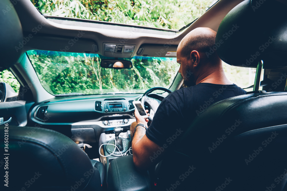 Bearded young man traveller connecting smartphone to dashboard for ...