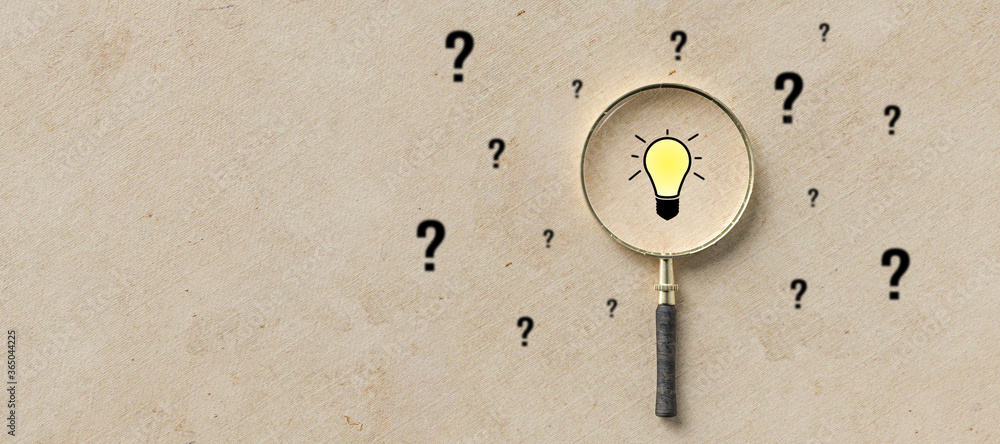 magnifying glass with lightbulb as symbol for finding a solution on ...