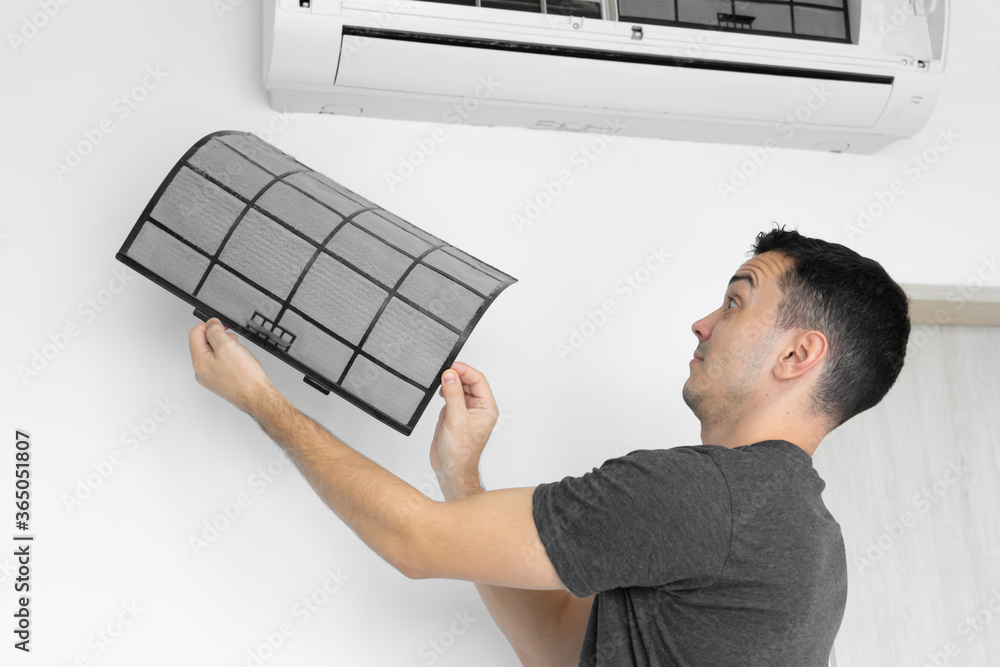 The guy cleans the filter of the home air conditioner from dust. Very ...
