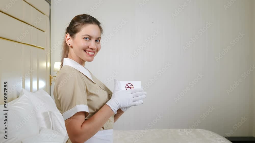 No smoking allowed sign in maid gloved hands. Portrait of ousekeeper ...