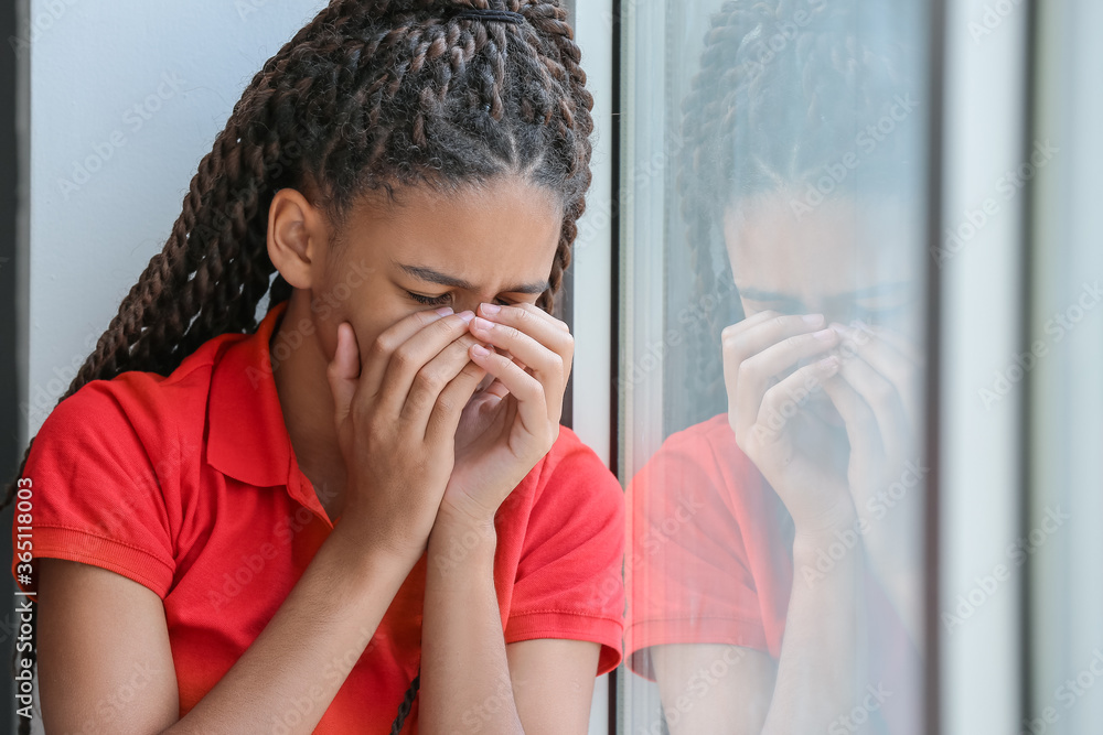 Sad African-American girl sitting on windowsill. Stop racism Stock ...