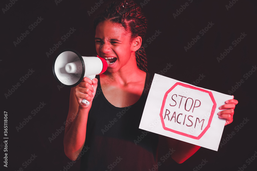 Angry African-American girl with poster and megaphone on dark ...