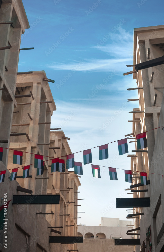 Garlands or small buntings of UAE flags displayed over old buildings in ...