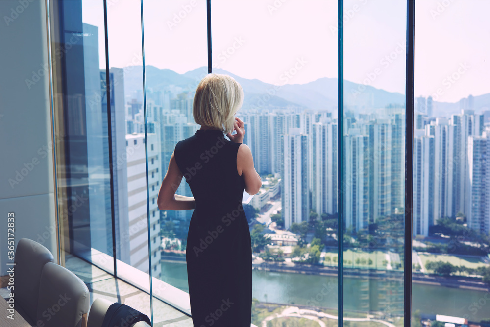 Back view of young successful businesswoman is having mobile phone ...