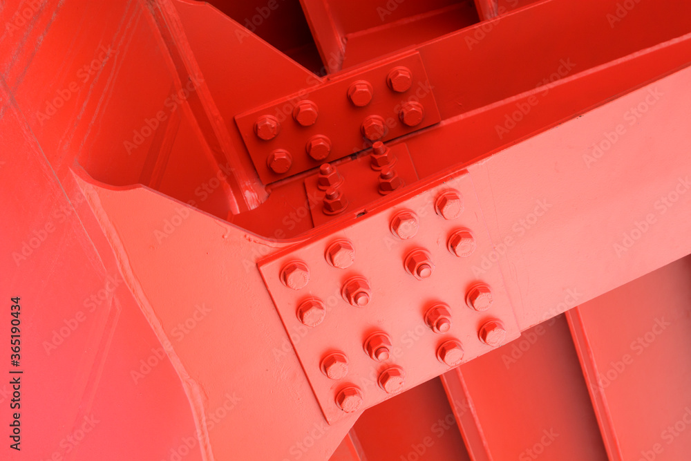 The red iron beam is bolted down. Close-up shows the connection of the ...