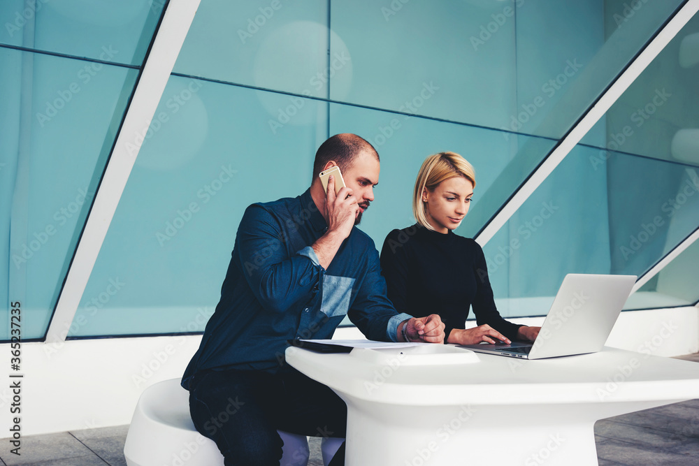 Young businessman talking on mobile phone with client while his ...