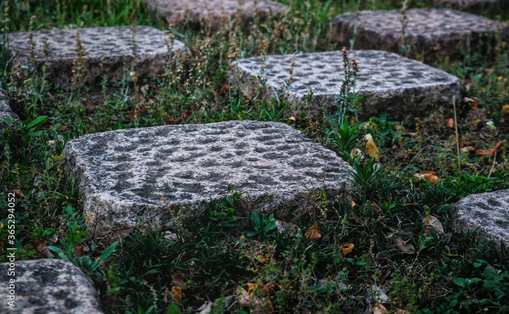 Sidelong perspective of a checkered pattern of dimpled stone tiles and ...