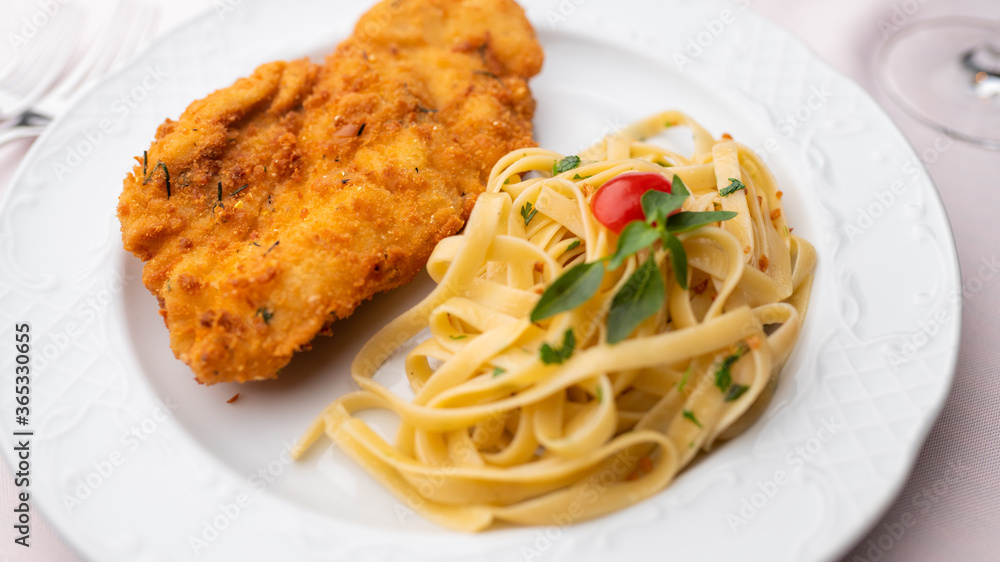 Frango à milanesa com alho e óleo de macarrão. foto de Stock | Adobe Stock