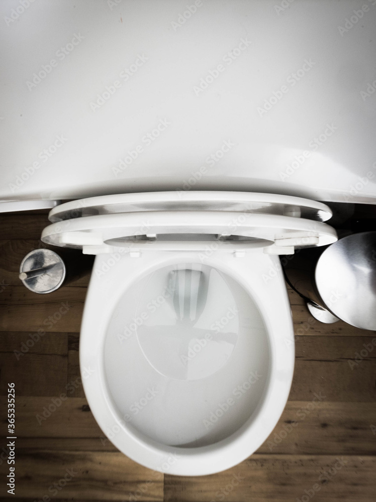 Toilet bowl shot from above with toilet bowl brush and trash bin on the ...