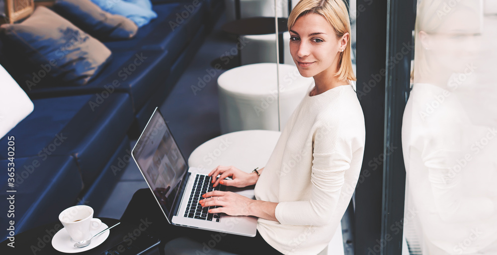 Gorgeous young woman sitting with open laptop computer in modern coffee ...