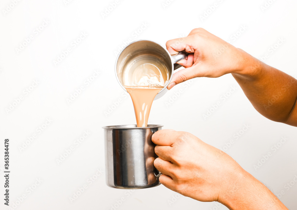 A close up picture of men preparing "teh tarik". Sweet milk tea been ...