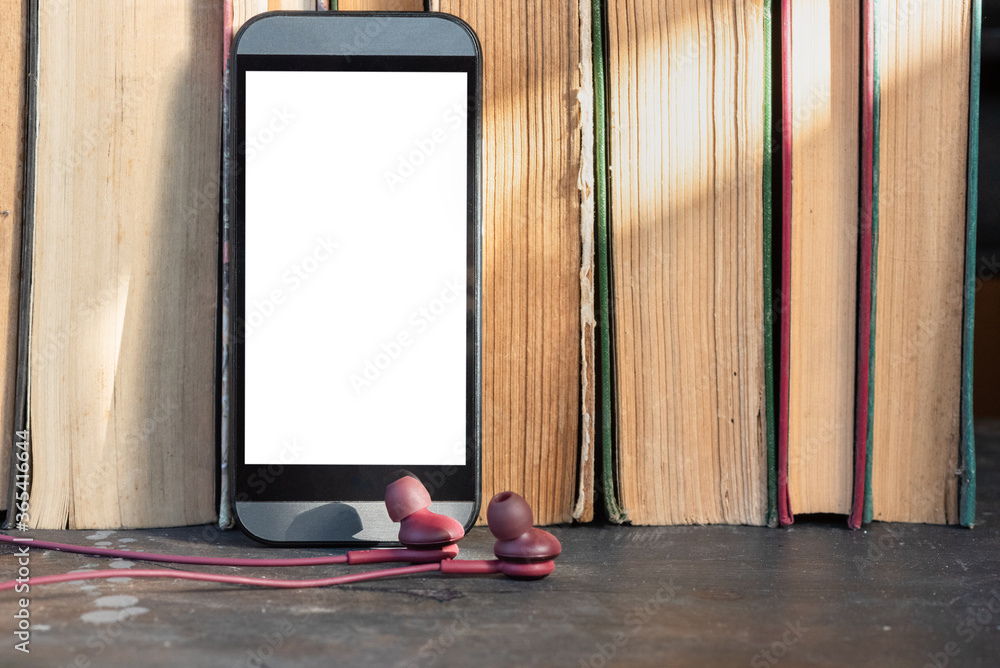 Mobile phone with blank screen with copy space and old books ...