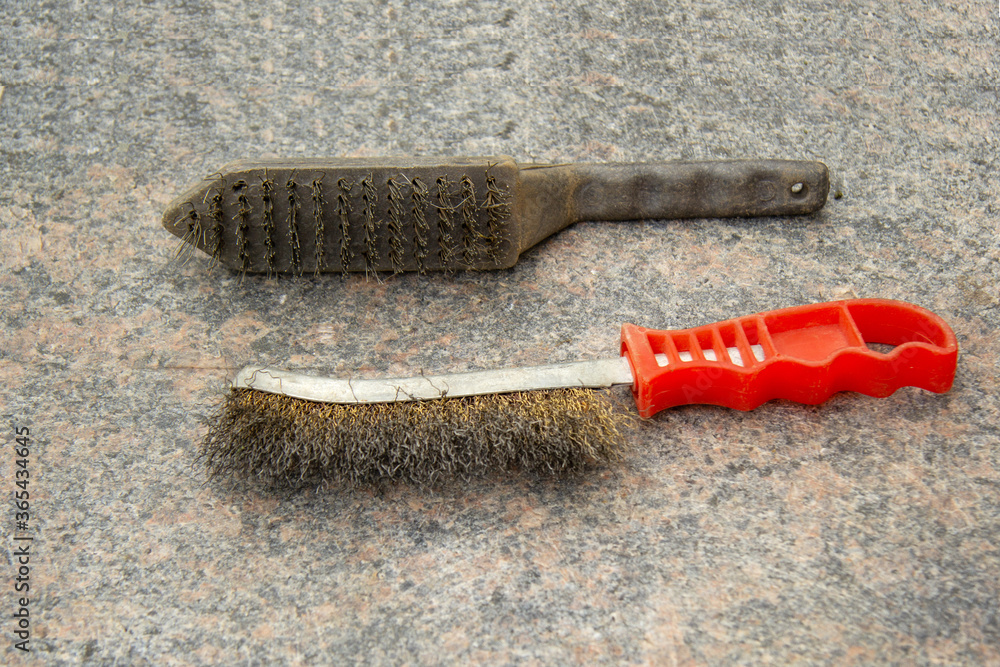 Two metal brushes with handles with different long metal bristles on a ...