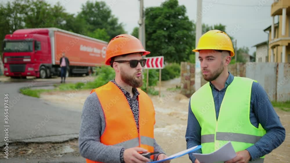 Two male engineers solve flood problem. Devastation wrought after ...