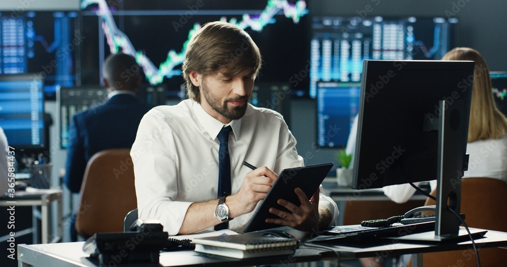 Male trader or broker working at stock exchange office using digital ...