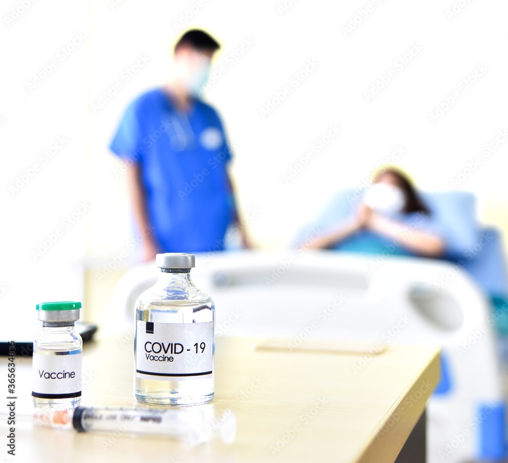 Covid-19 Vaccine bottle and syringe put on table with blur background ...