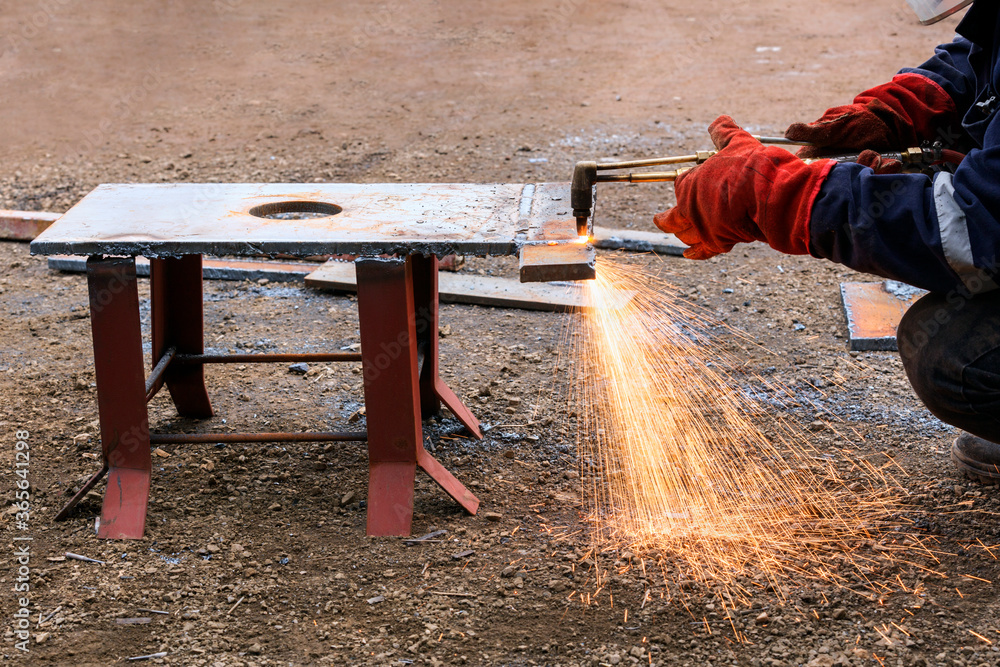 Cutting steel plate with flame. In oxy-fuel cutting, a torch is used to ...