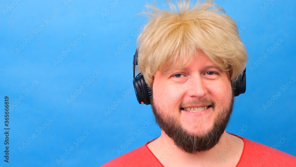 laughing freaky fat man in a wig and a pink T-shirt in his hands ...