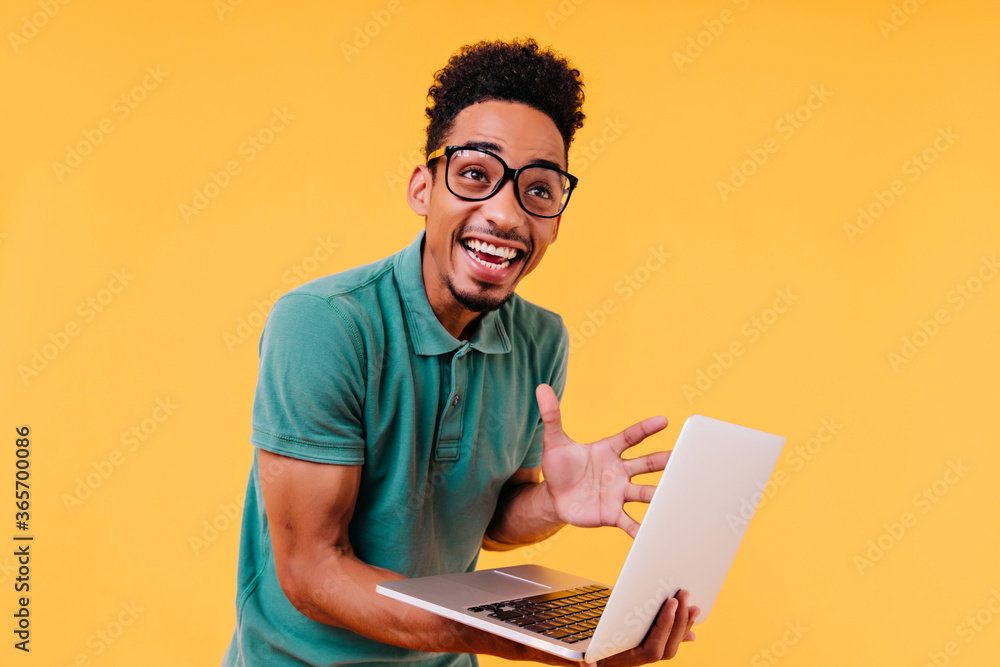 Laughing black man in glasses expressing excitement on yellow ...