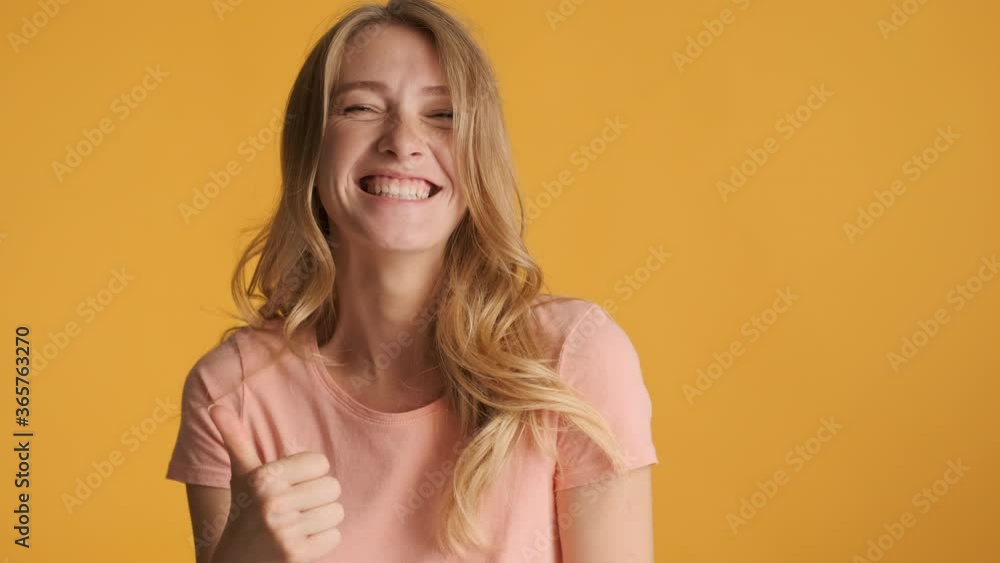 Attractive excited blond girl happily showing yes and thumb up gestures ...