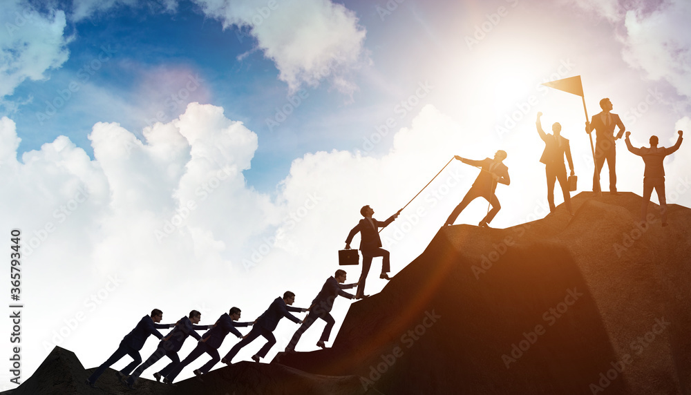 Concept of teamwork with team climbing mountain top Stock Photo | Adobe ...