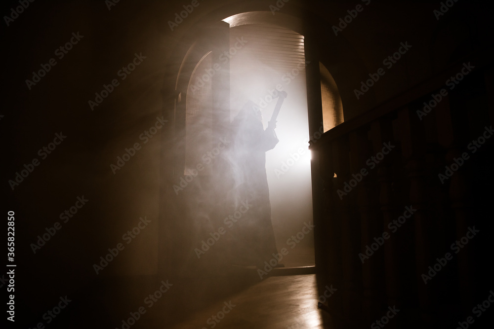 Silhouette of an unknown shadow figure on a door through a closed glass ...