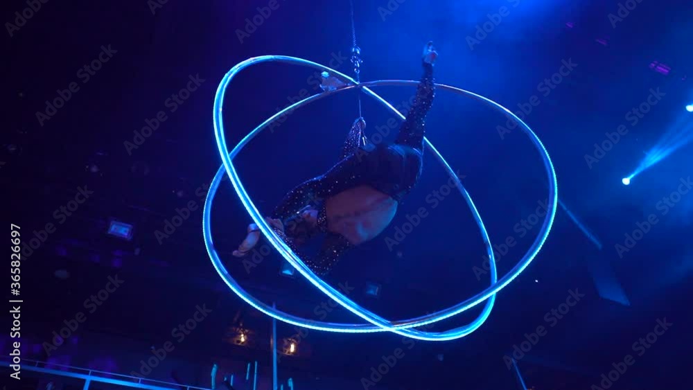 Flexible girl doing splits in aerial acrobatic hoop upside down ...