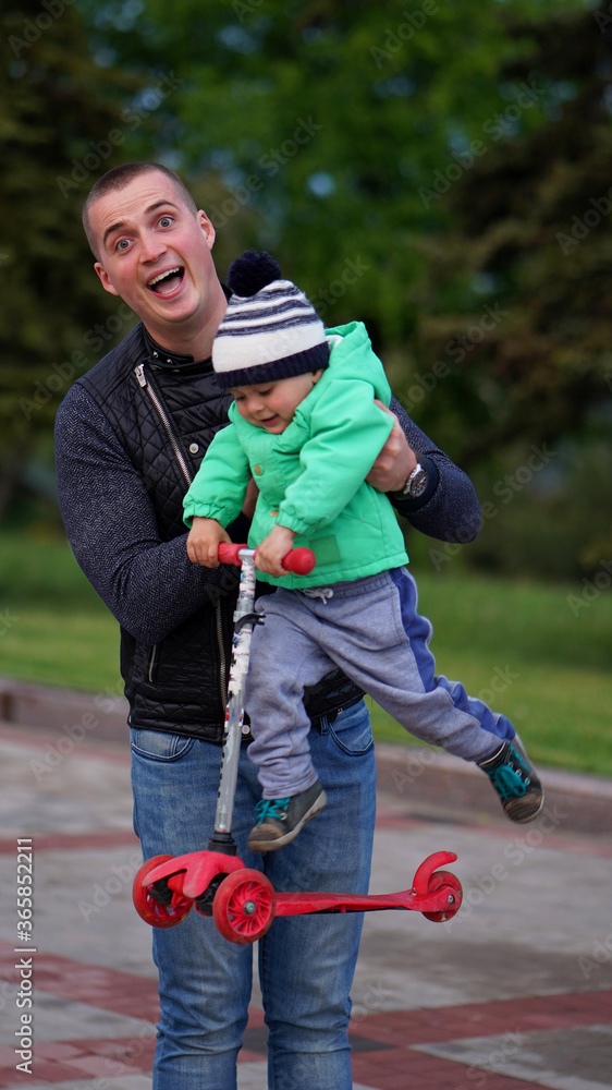 Big man with little boy in park. The laughing guy holding child with ...