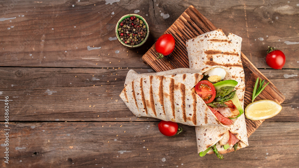 Tortilla wrap with asparagus, cherry tomatoes, avocado, chicken fillet ...