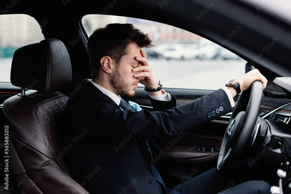 Sad businessman driving alone in his new car Stock Photo | Adobe Stock
