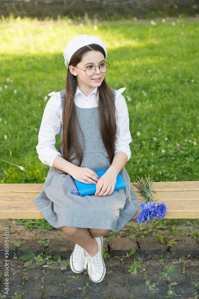 Define your style. Small child sit on bench outdoors. Little girl wear ...