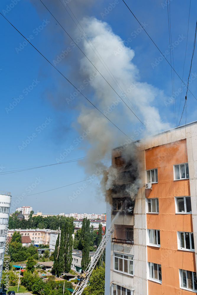fire on the balcony of a multi-storey building, black clouds of smoke ...