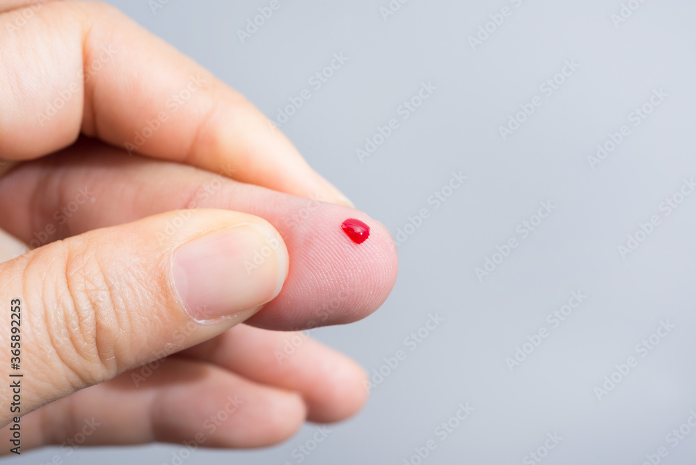 Blood drop on fingertip prepare for checking the glucose level with a ...