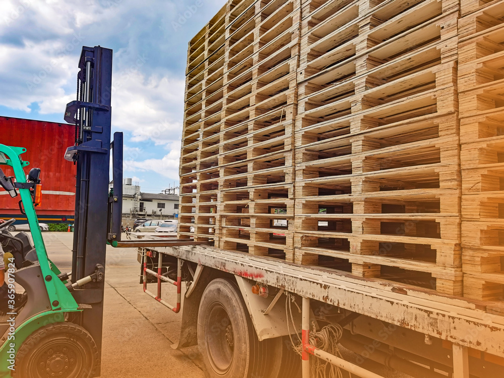 Worker driving forklift to loading and unloading wooden pallets from ...