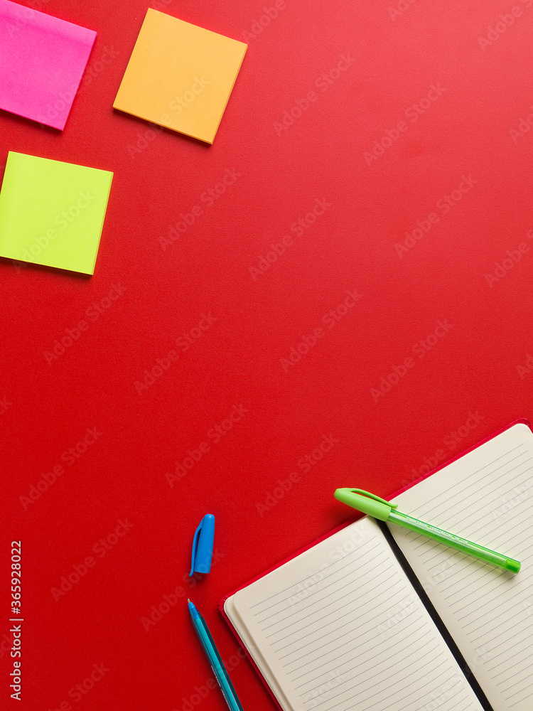 Top view of an open blank red notebook in the bottom corner with a ...