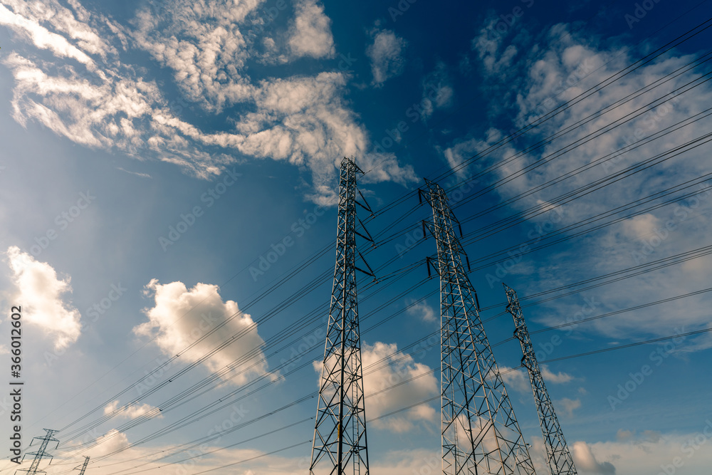 High voltage electric pylon and electrical wire against blue sky and ...