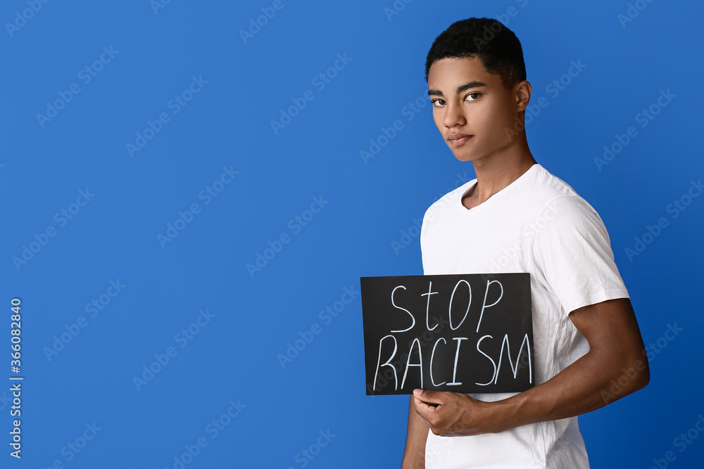 Sad African-American teenage boy with poster on color background. Stop ...