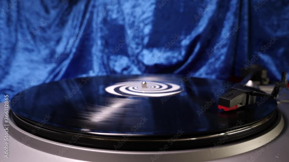 Stylus arm and needle lowered on 12” black vinyl record on DJ turntable ...