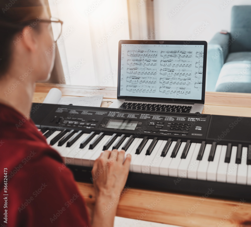 A woman is taking piano lessons online. Education at home. Music notes ...