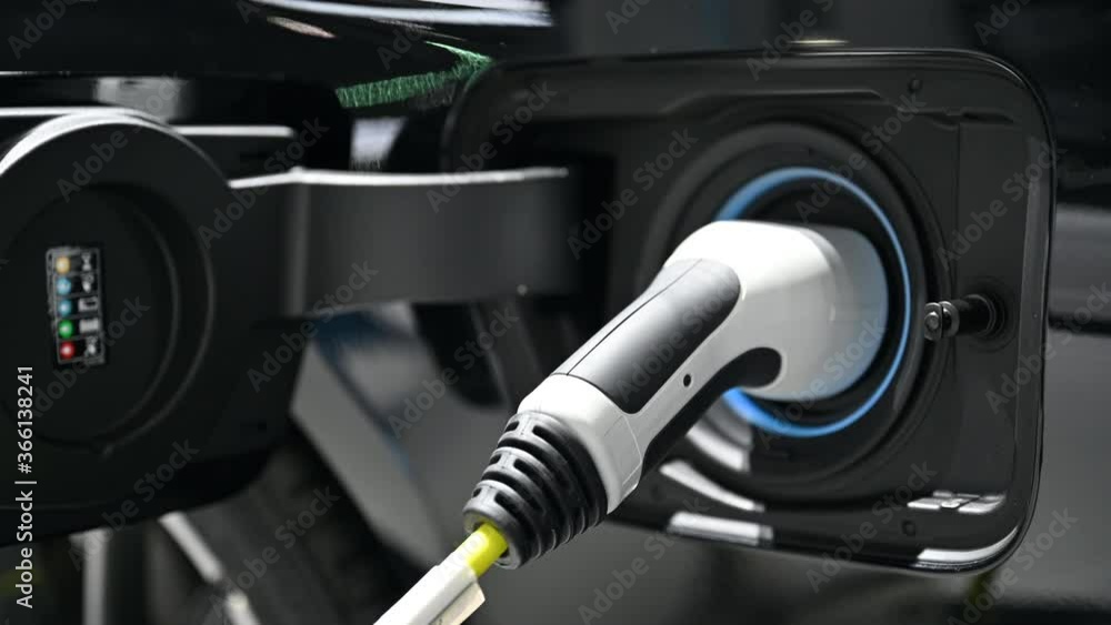 Electric vehicle charging port plugging in EV modern car. save ecology ...