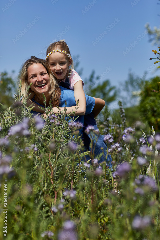 Happy mother carrying daughter piggyback in allotment garden Stock ... Happy mother carrying daughter piggyback in allotment garden Stock ...