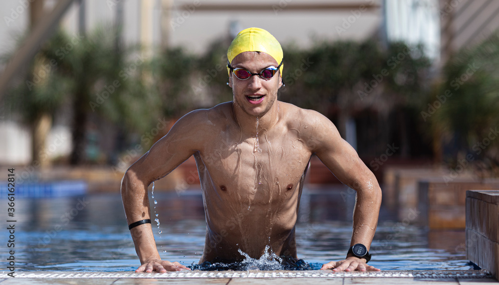 Confident swimmer coming out from pool at tourist resort, Dubai, United ...