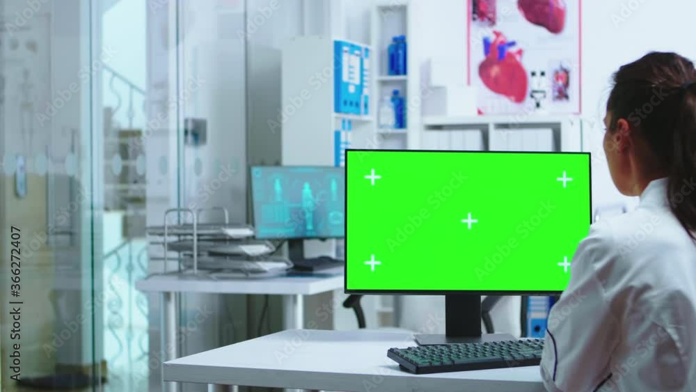 Doctor specialist using computer with green screen in modern hospital ...