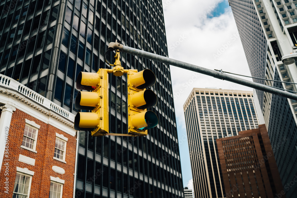 Yellow traffic light hanging over roads in downtown controlling ...