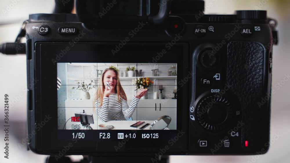 Camera screen recording - vlogger female applies lipstick on lips ...