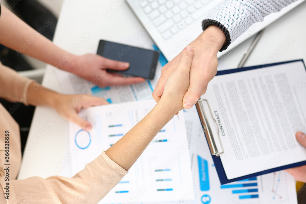Kind male person standing opposite his partner and shaking hands after ...