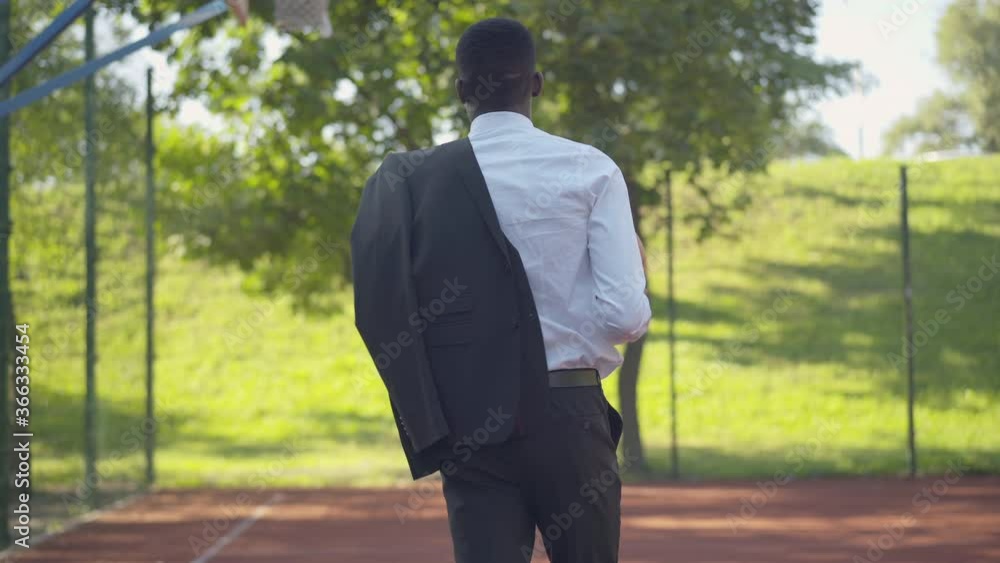 Camera follows young African American businessman entering outdoor ...