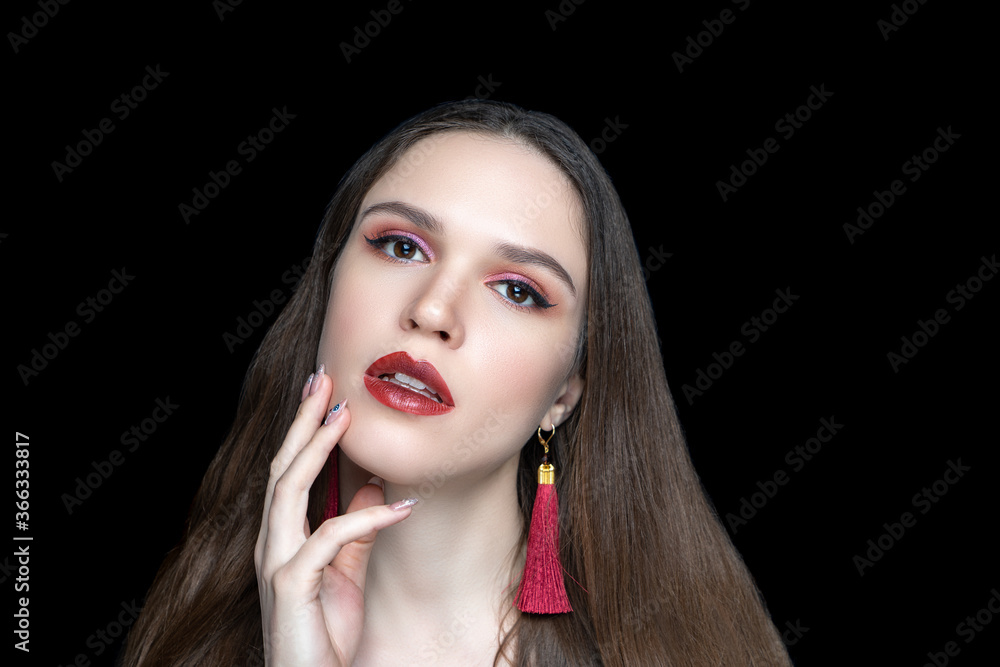 Young beautiful girl looks emotionally and touches her chin ...