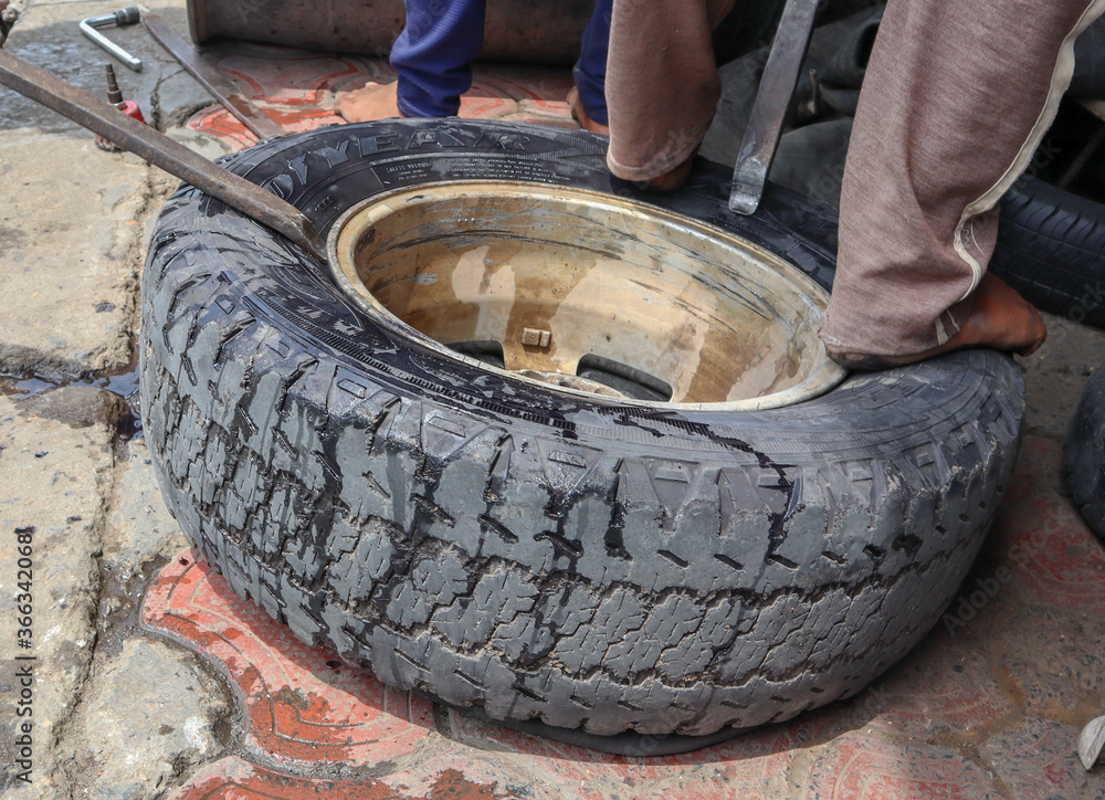 Ujjain, India - July 20th 2020: A Indian Man repairing a large size ...