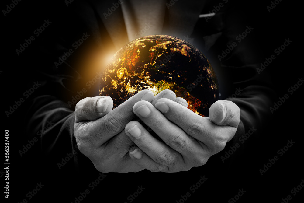 Environment concept. Earth with light in hands on black background ...